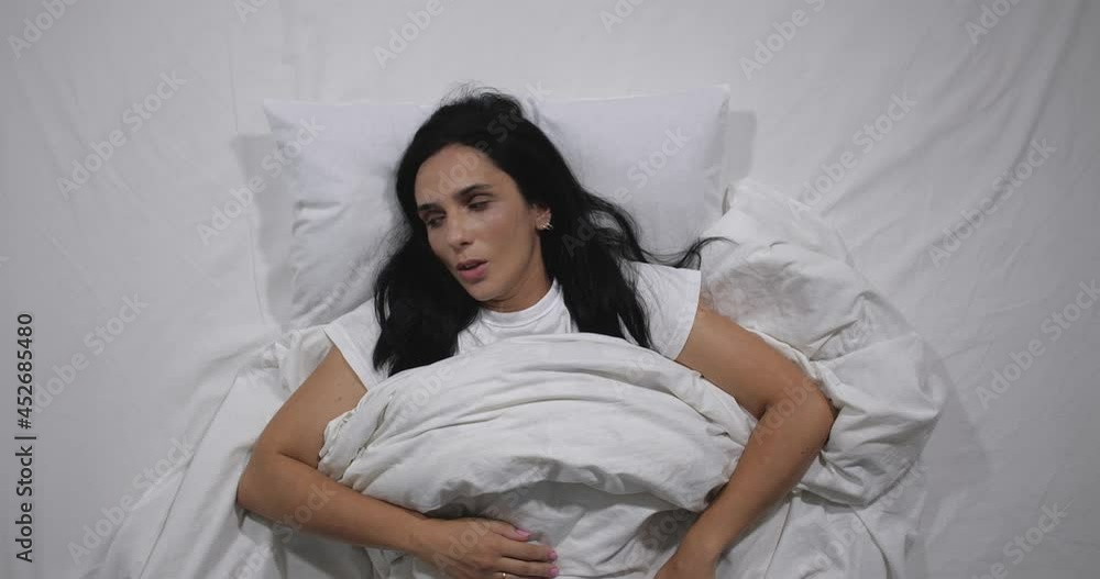 Top view of attractive caucasian young woman sleeping in bed with white ...