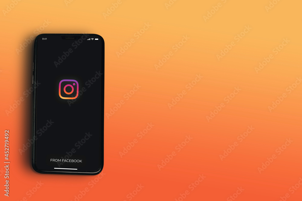 Instagram app on smartphone screen on orange background. Social media ...