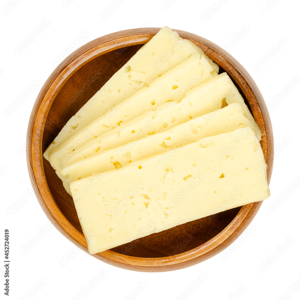 Tilsit cheese slices, in a wooden bowl. Sliced Tilsiter cheese, a pale ...
