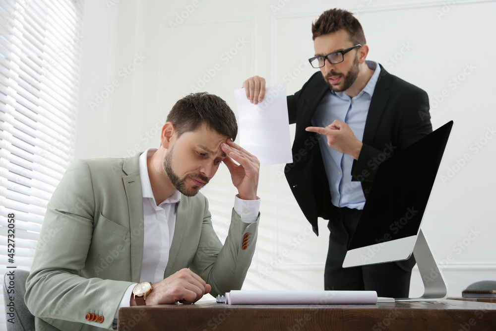 Boss scolding employee in office. Toxic work environment Stock Photo ...