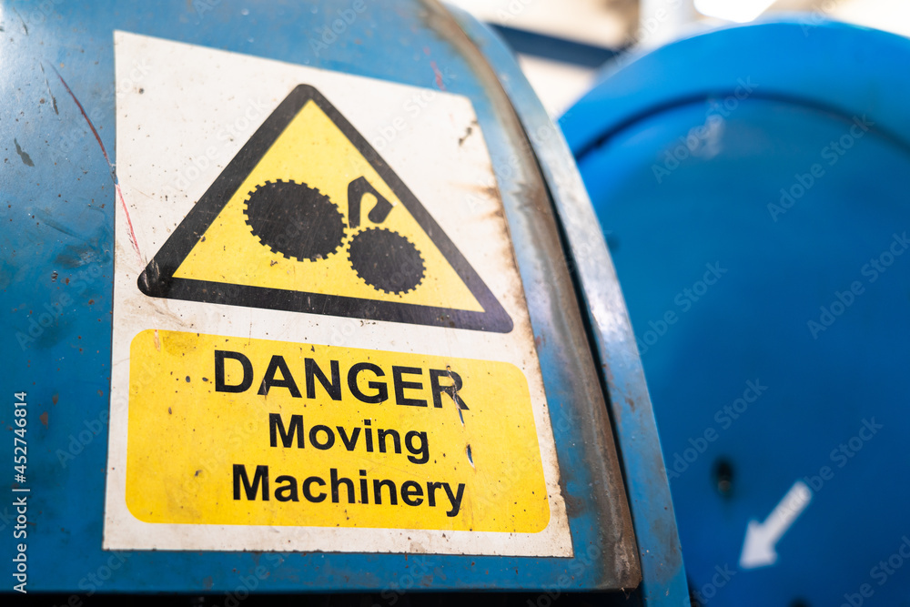 "Moving machinery" danger caution sign on the heavy machine in the ...