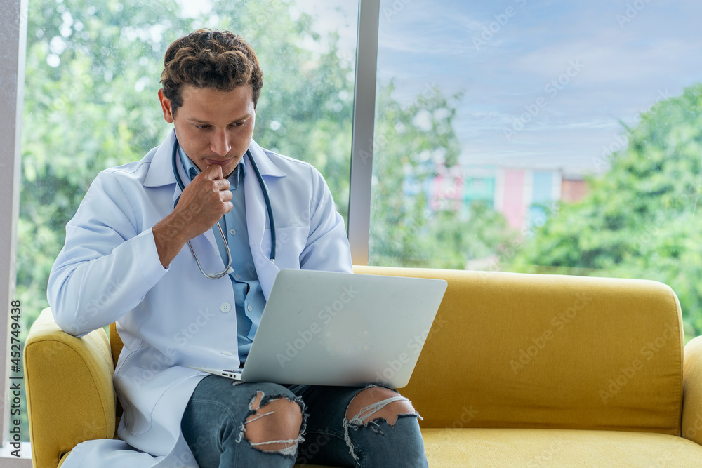 Handsome doctor works reading patient reports from laptop and patient ...