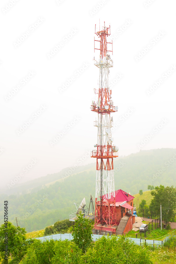 Red and white communication tower with antennas against the background ...