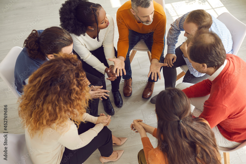 Professional therapist meeting with multiracial group therapy patients ...