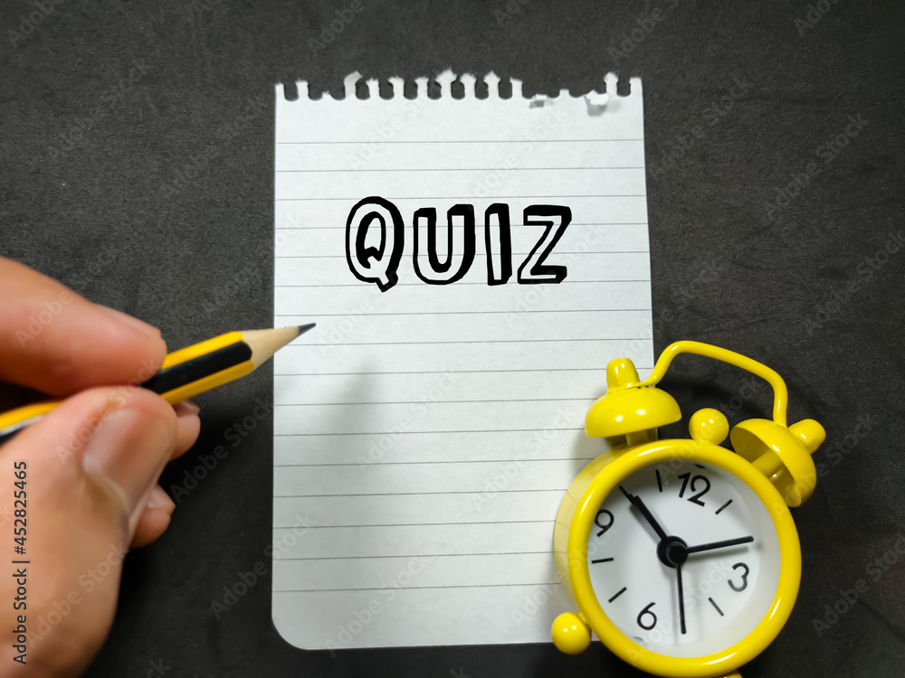 Education concept.Text QUIZ writing on notepaper with hand holding ...