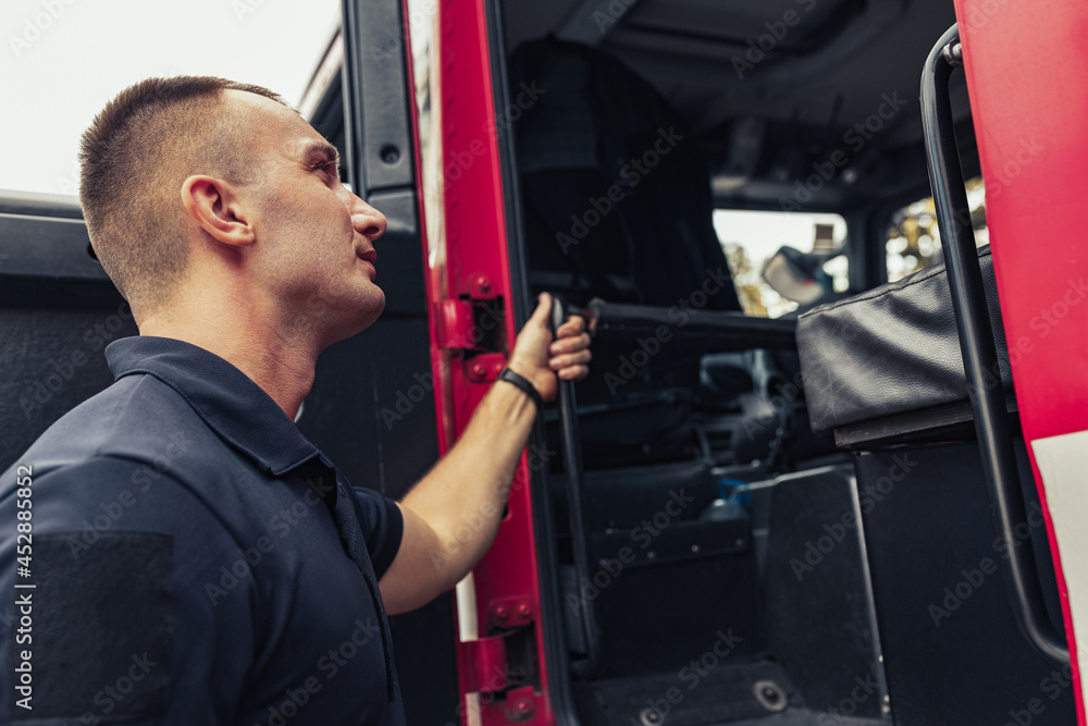 Fireman by fire truck using professional firefighting equipment Stock ...