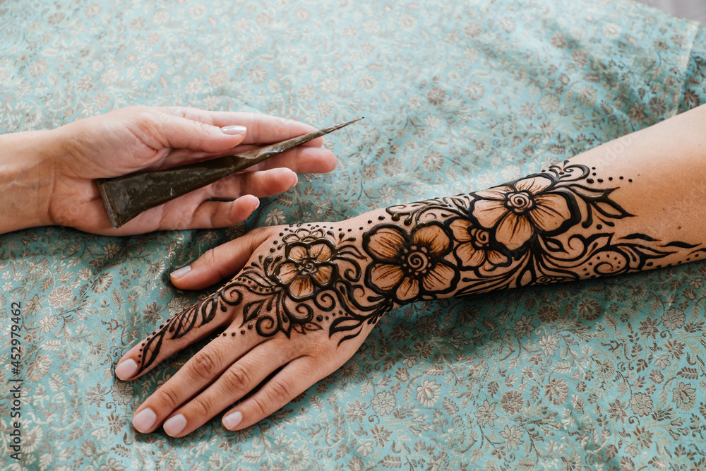 Top view art henna tattoo on woman hands. master artist drawing Arabic ...
