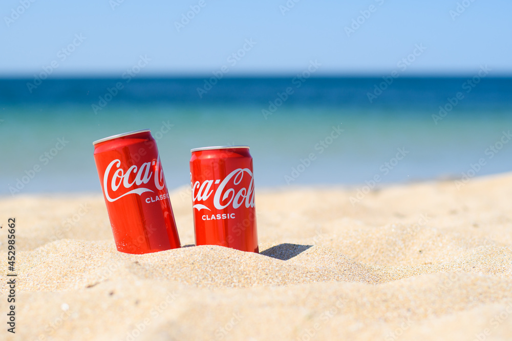 Anapa, Russia - July 2021: Two red cans of Coca-Cola stand buried in ...
