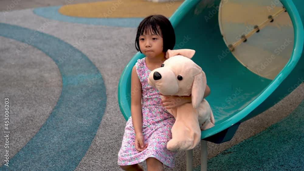 Boring little girl bring dog plush toy sit at bottom of slide Stock ...