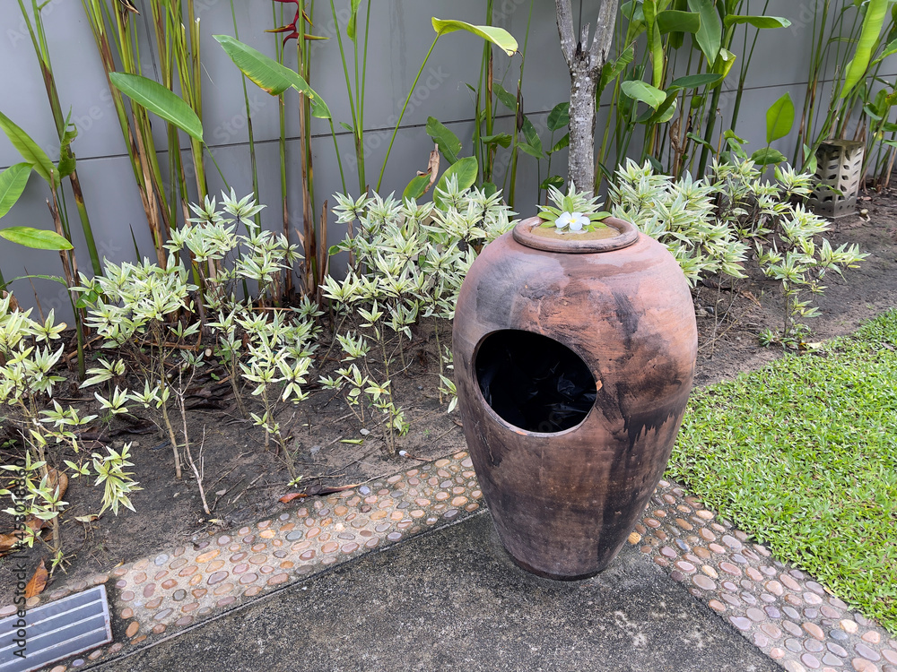 Thai style pottery Trash bin in tropical garden. D.I.Y (Do It Yourself ...