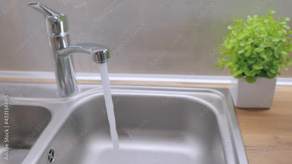 Tap water flows from the tap. Drinking water at the tap. Faucet in the ...
