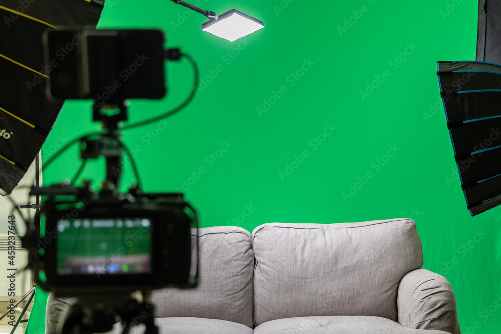 a gray couch stands in front of a green screen. Background ...