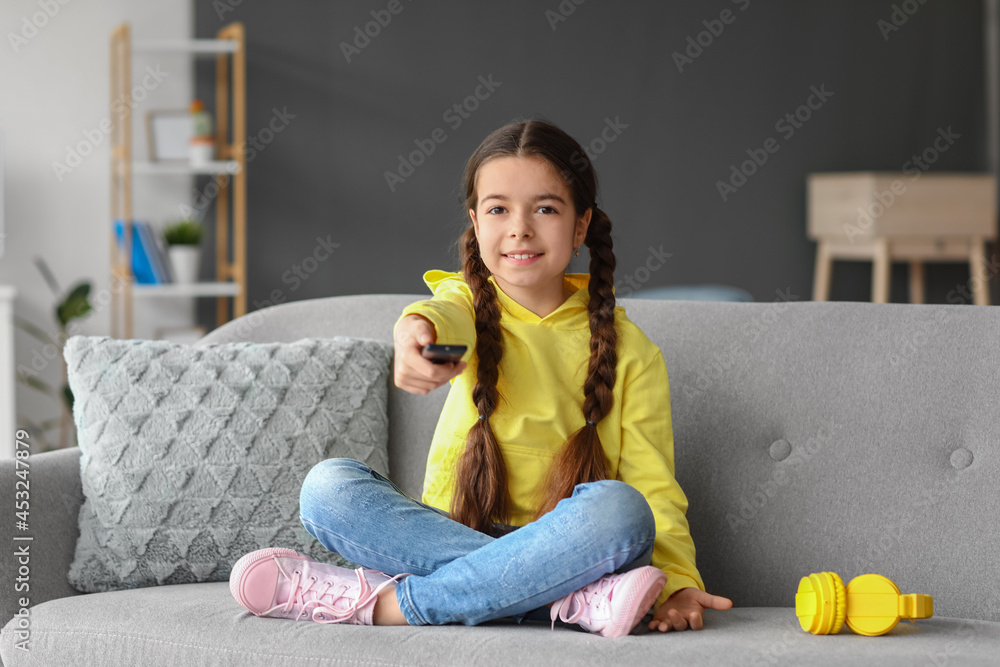 Cute girl watching cartoons at home Stock Photo | Adobe Stock
