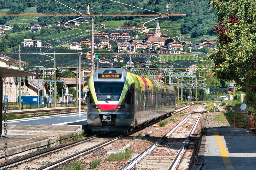 Ein farbenfroher Zug der italienischen Eisenbahn fährt in den Bahnhof ...