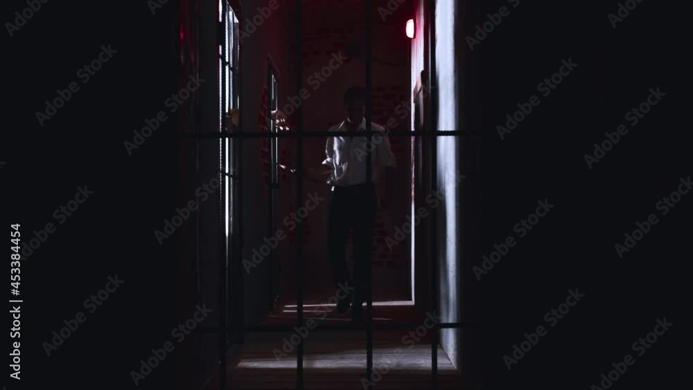 Horror acting - a dangerous male warden walks by the cells in the ...