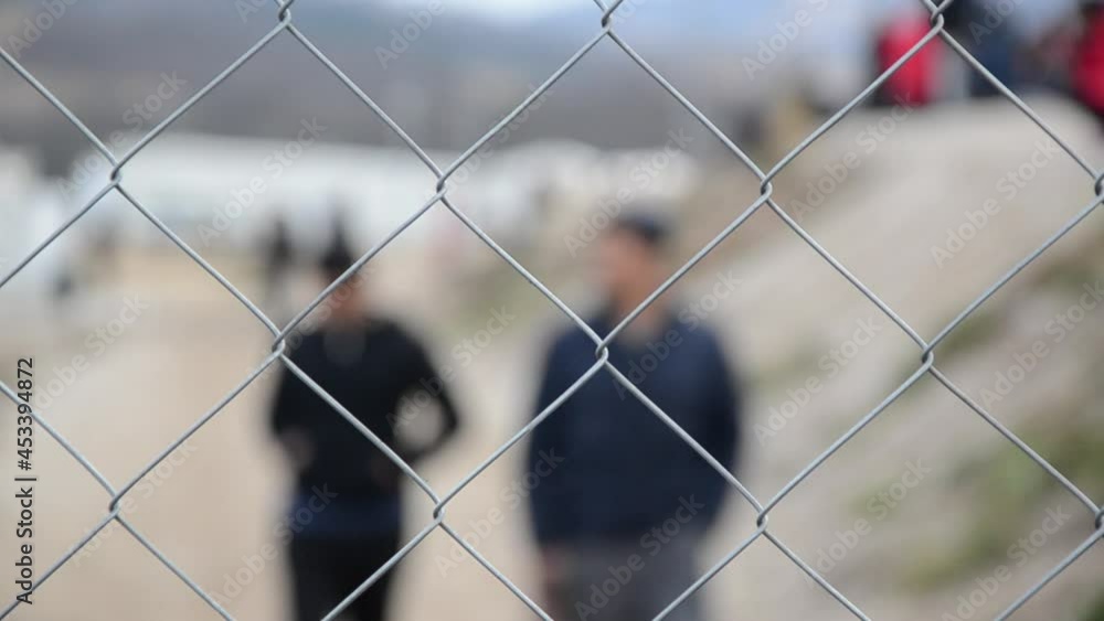 Vidéo Stock Barbed wire in refugee camp. Migrants behind chain link ...