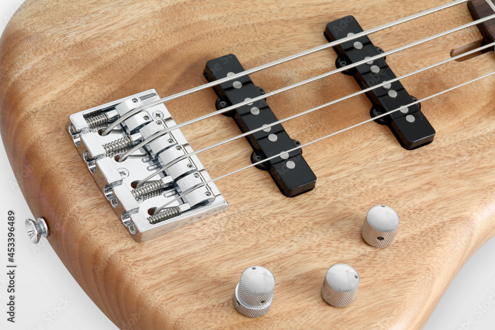Electric bass guitar's detail with pickups, strings, bridge, volumes ...