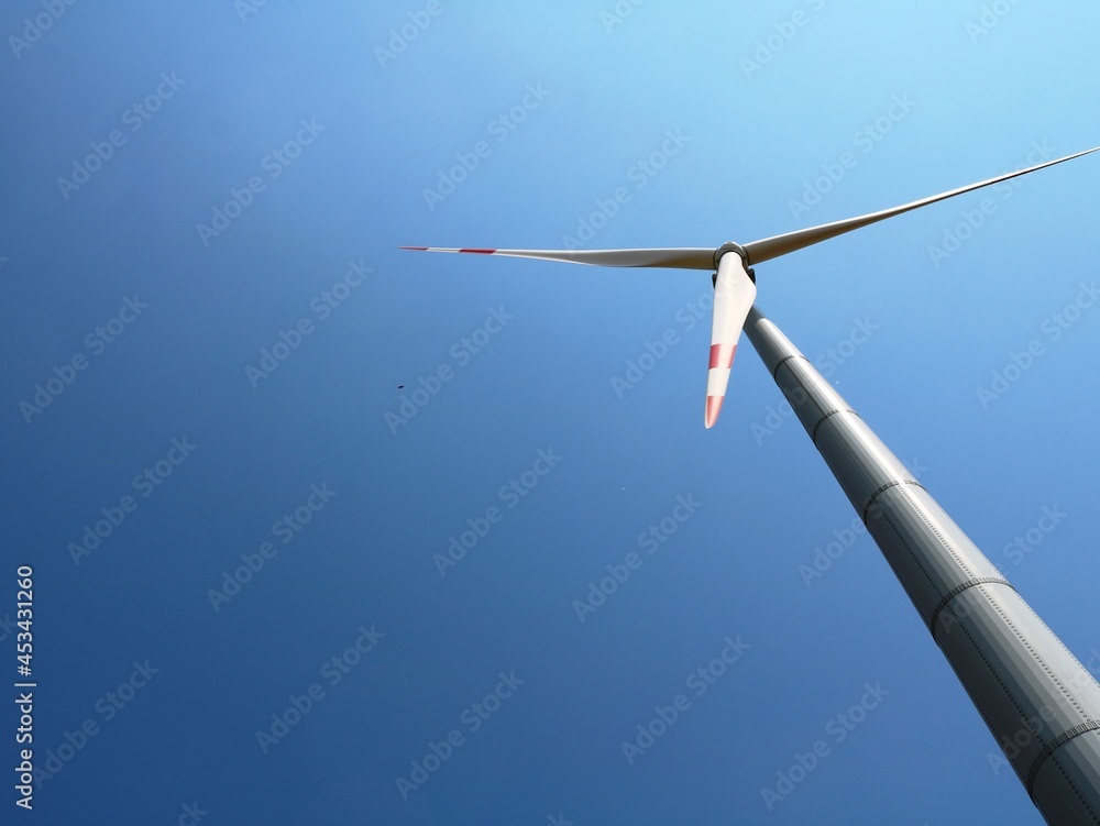 windmill generator with red stripes on the blades close-up against a ...