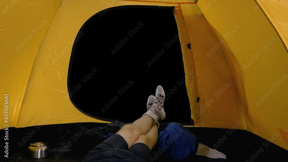 Vidéo Stock Male hiker in shorts lying inside open tent, view of legs ...
