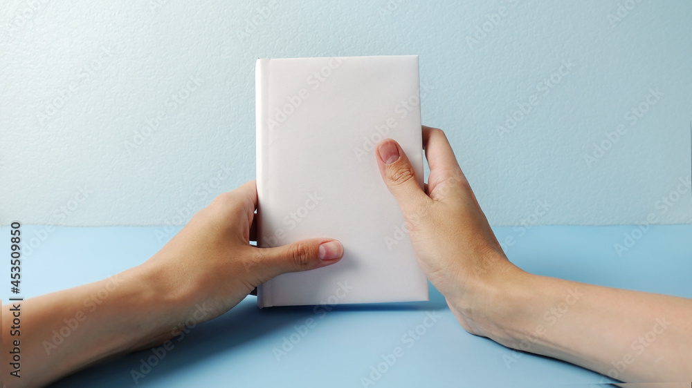 Book cover template mock up. Two female hands are holding a blank book ...
