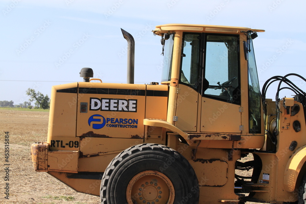 Yellow John Deere front end loader out in the country shot closeup on a ...