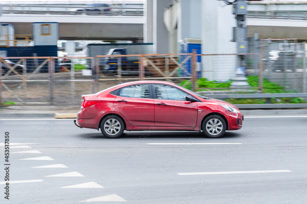 Red color sedan Hyundai Solaris (Accent) fast speed driving on the city ...