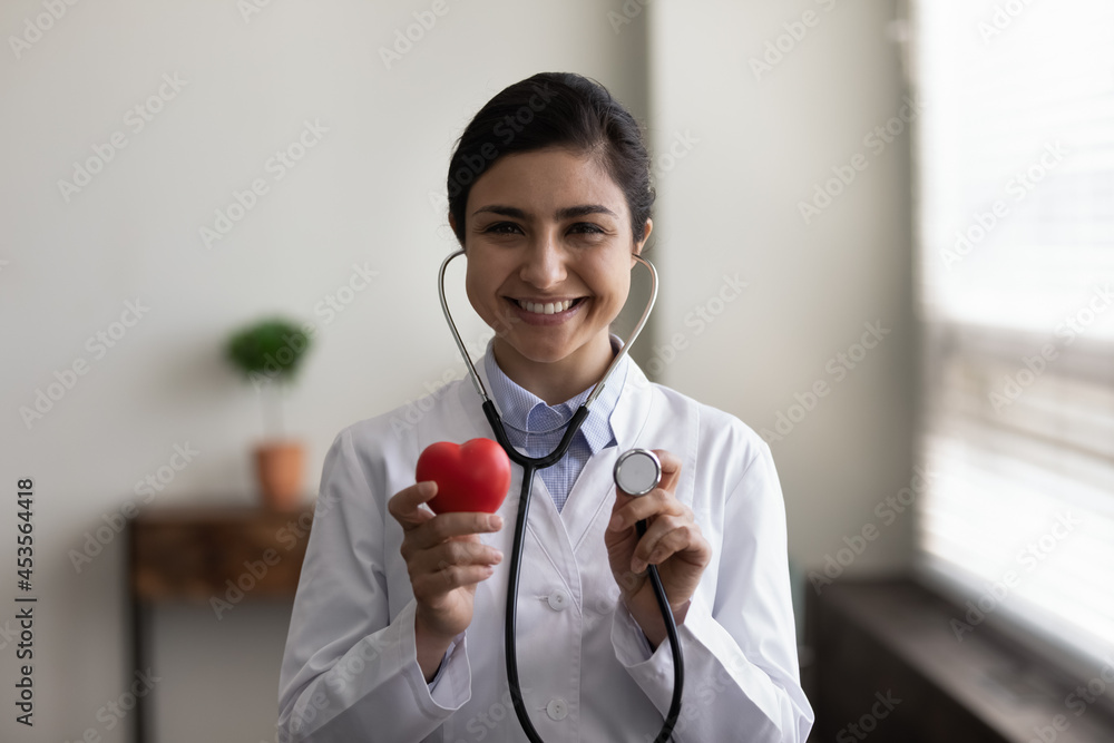 Smiling young professional female indian ethnicity cardiologist wearing ...