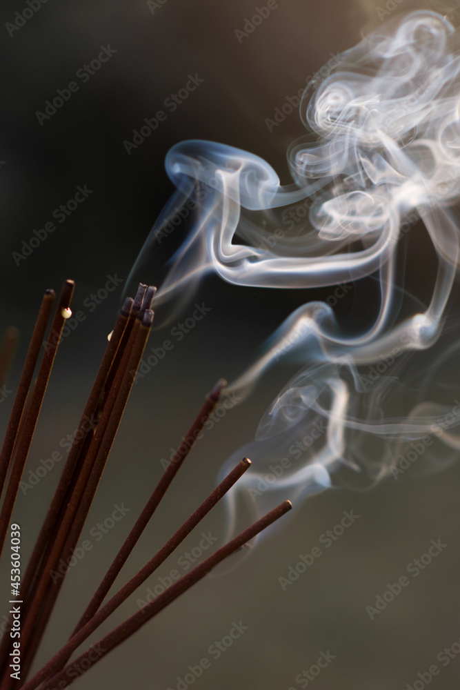Incense sticks and smoke from incense sticks on a black background with ...