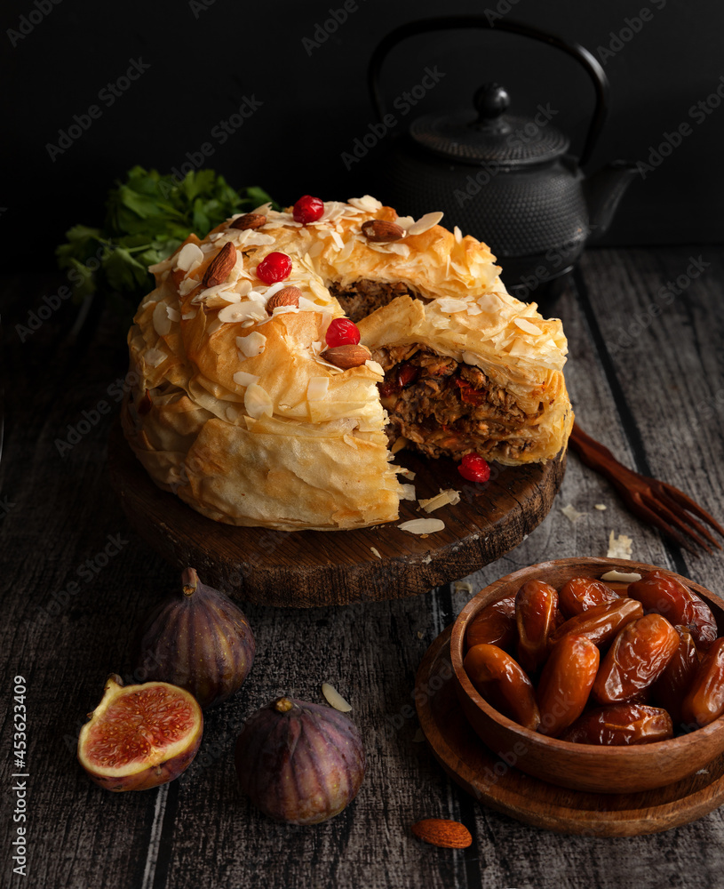 Moroccan pastila pie (bastela) on a wooden background. Chicken Bastille ...