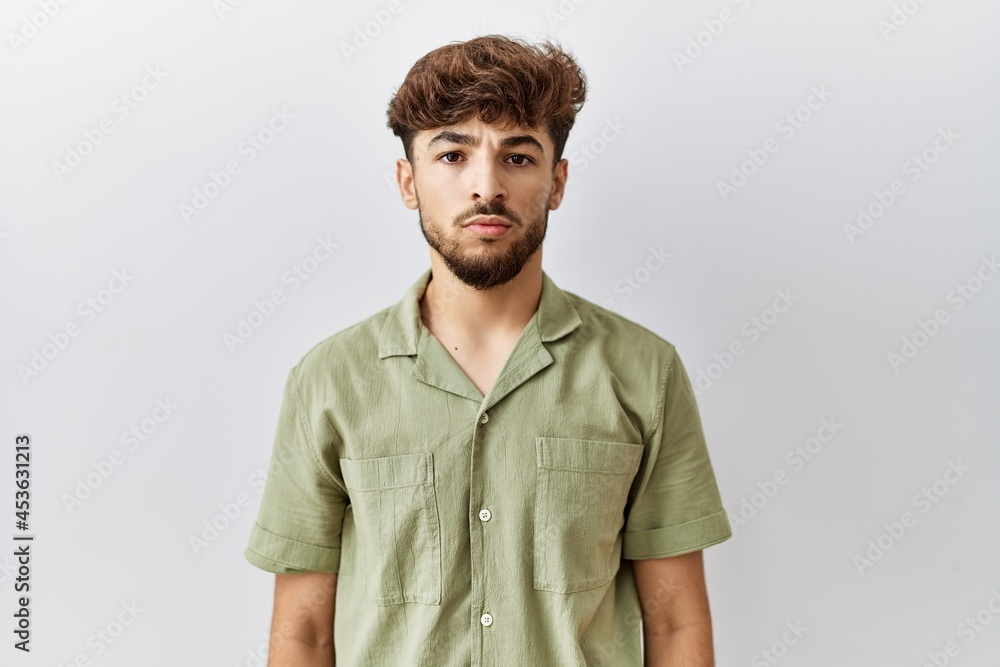 Young arab doctor man standing over isolated background relaxed with ...