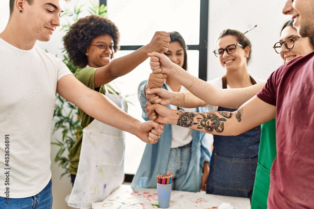 Group of young draw students smiling happy standing with fist together ...