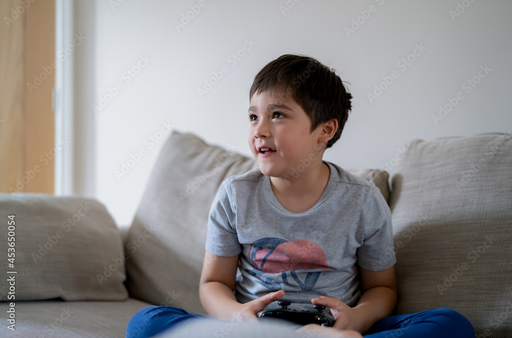 Young boy playing video games online, Candid shot Happy mixed race ...