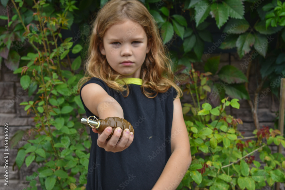 child girl found a combat grenade outside the photo without processing Stock Photo | Adobe Stock
