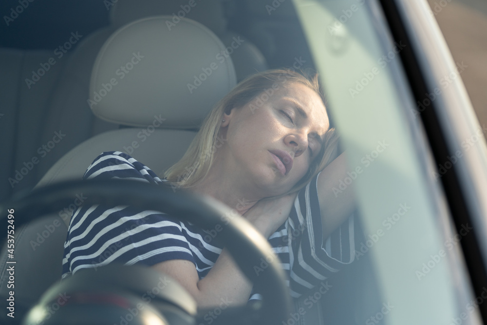 Relaxed woman tired of driving car sleep on front seat. Middle age ...