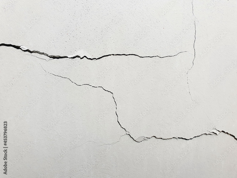 The cracks in the gray cement wall were visible as long fissures. This ...