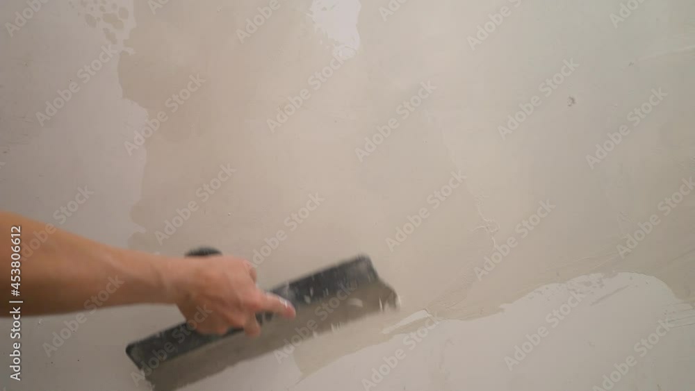 The plasterer levels the wall before gluing the wallpaper. The process ...