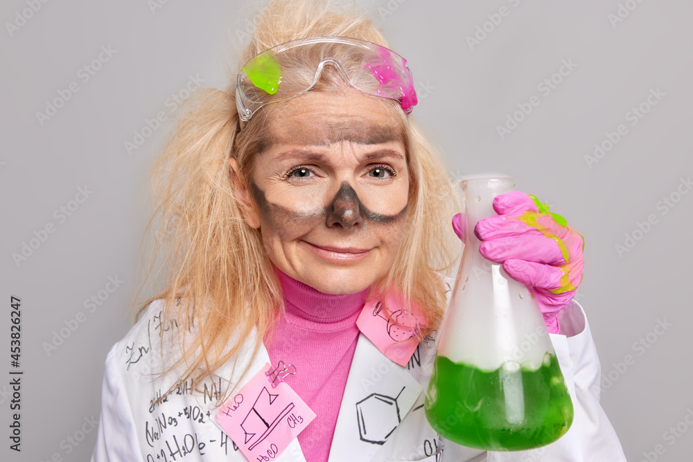 Serious female scientist at work conducts experiment in lab holds ...