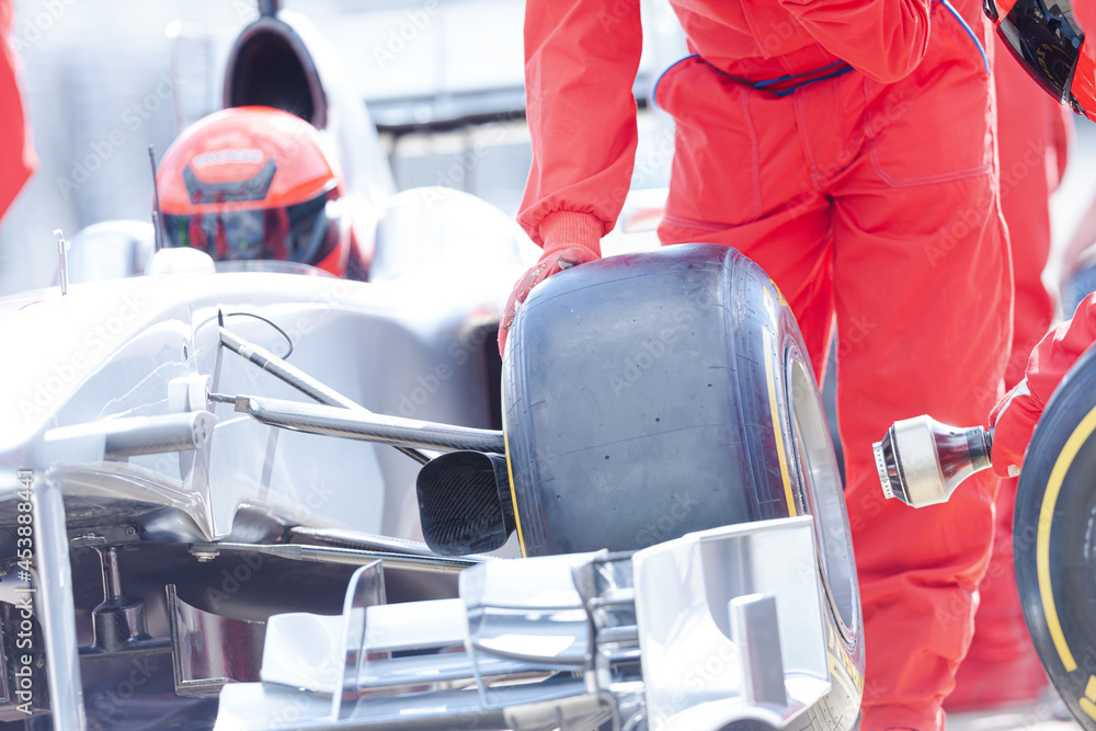 Racing team changing car wheel on pit stop Stock Photo | Adobe Stock