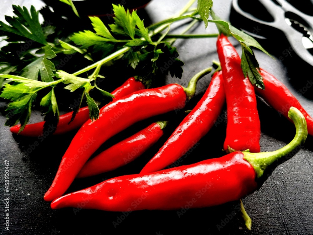 scharfe Peperoni auf dem Schneidebrett mit Petersilie und Schere Stock ...