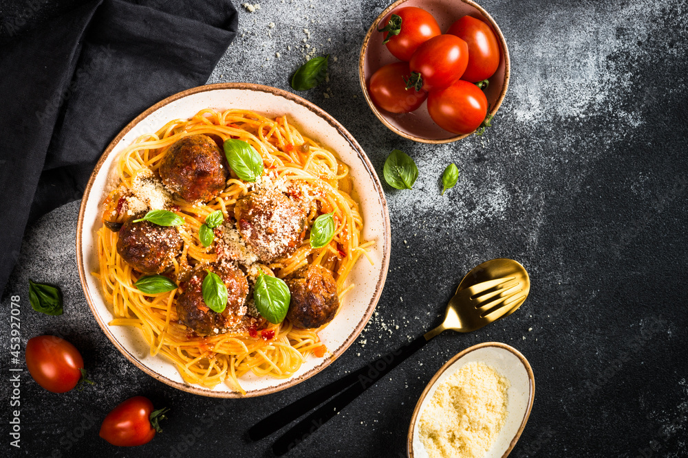 Pasta with Meatballs in tomato sauce, basil and parmesan on dark stone ...