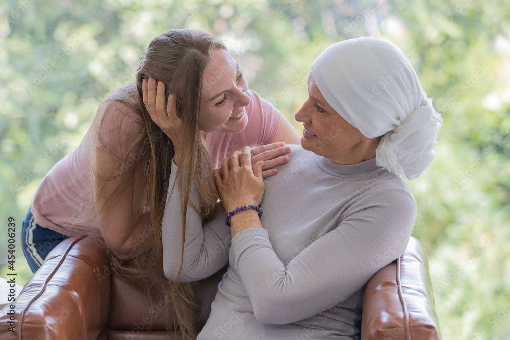 Woman and female cancer patient cuddle together for the symbol of ...