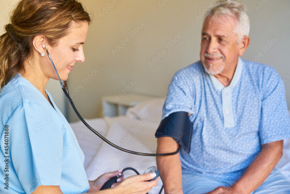 Nurse with stethoscope carefully measures blood pressure Stock Photo ...