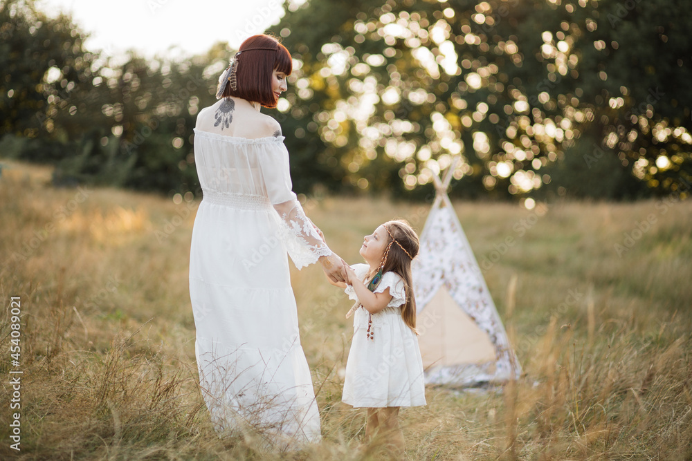 Foto de Happy stunning native American mother dancing with her adorable little daughter, holding ...