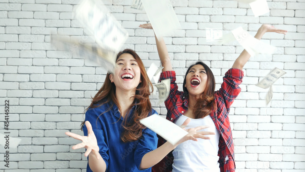 Happy young asian woman holding dollar money and throw in the air ...