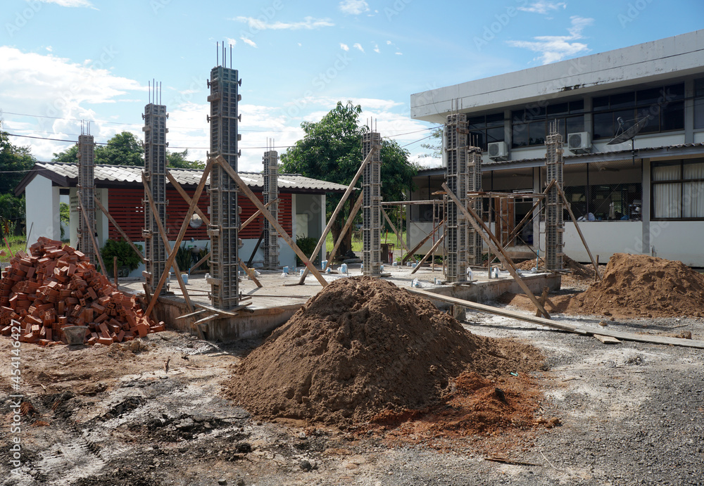 Steel binding and pole entry on construction site with a pile of sand ...