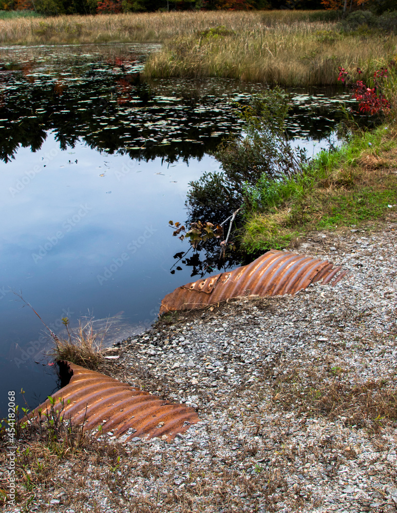 rusty old colorful drain pipes on the edge of a pond Stock Photo ...