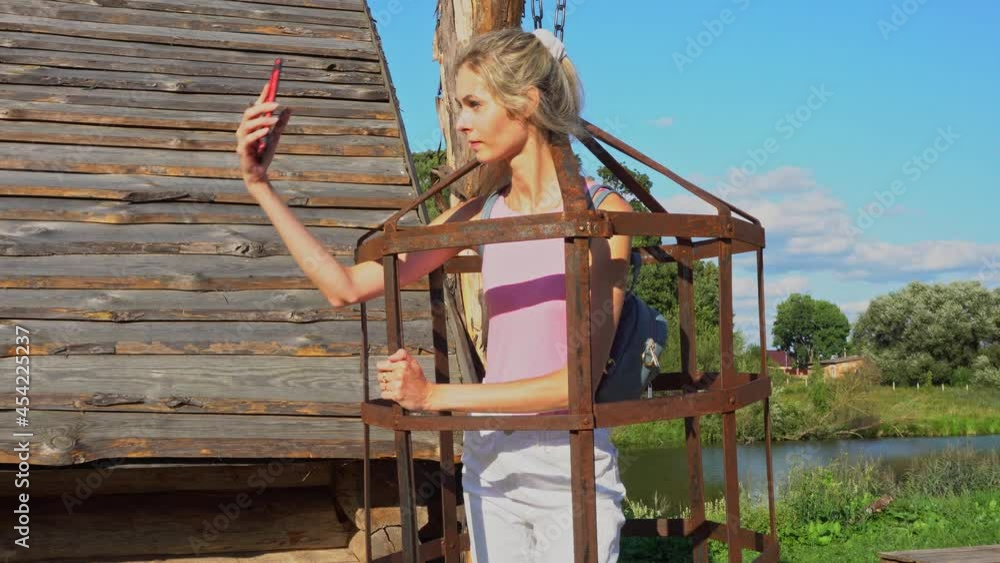 Young beautiful girl is take a photo in a hanging cage for torturing ...