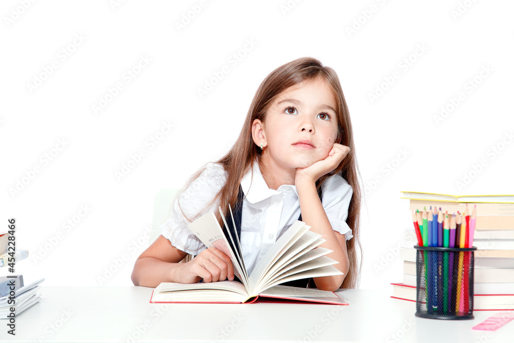 Cute little child girl looking up on the desk at school. Stock Photo ...