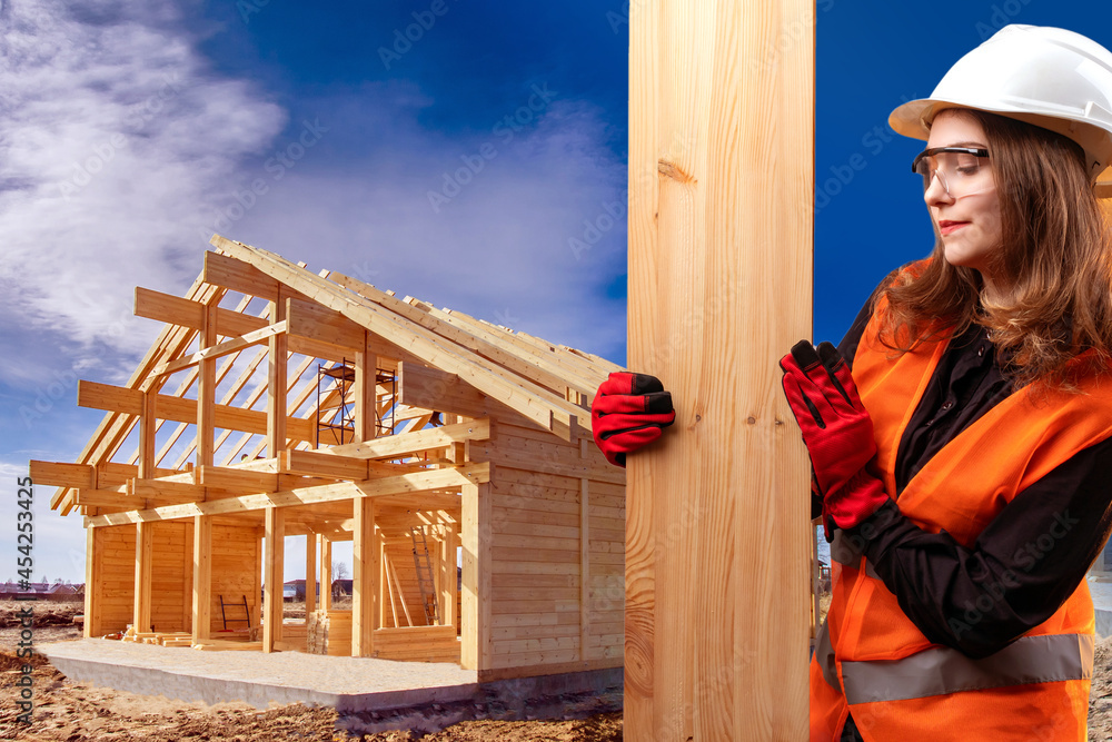 A builder next to timber frame. Wood construction concept. Unfinished ...
