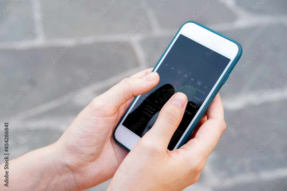 Stock market investor hands holding a phone investment app index growth ...
